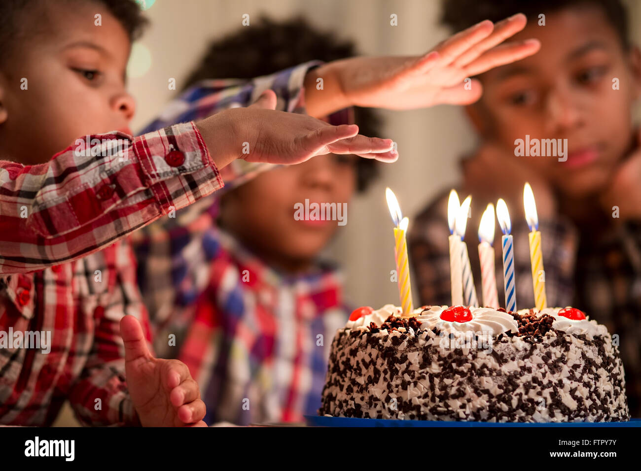 Boy's hand over cake's candle Stock Photo - Alamy