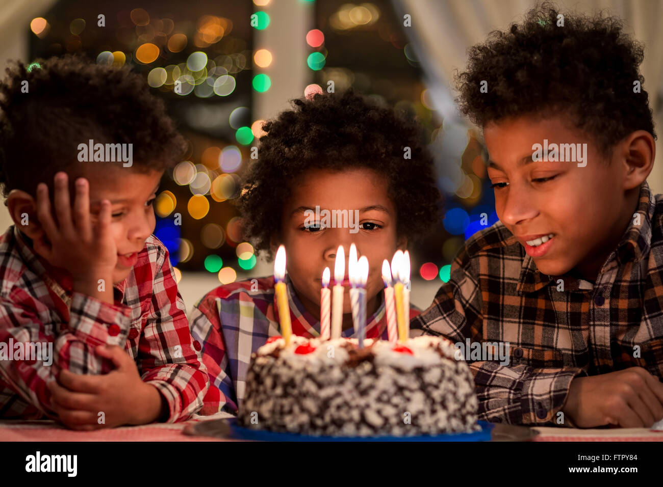 Kids sitting beside birthday cake Stock Photo - Alamy