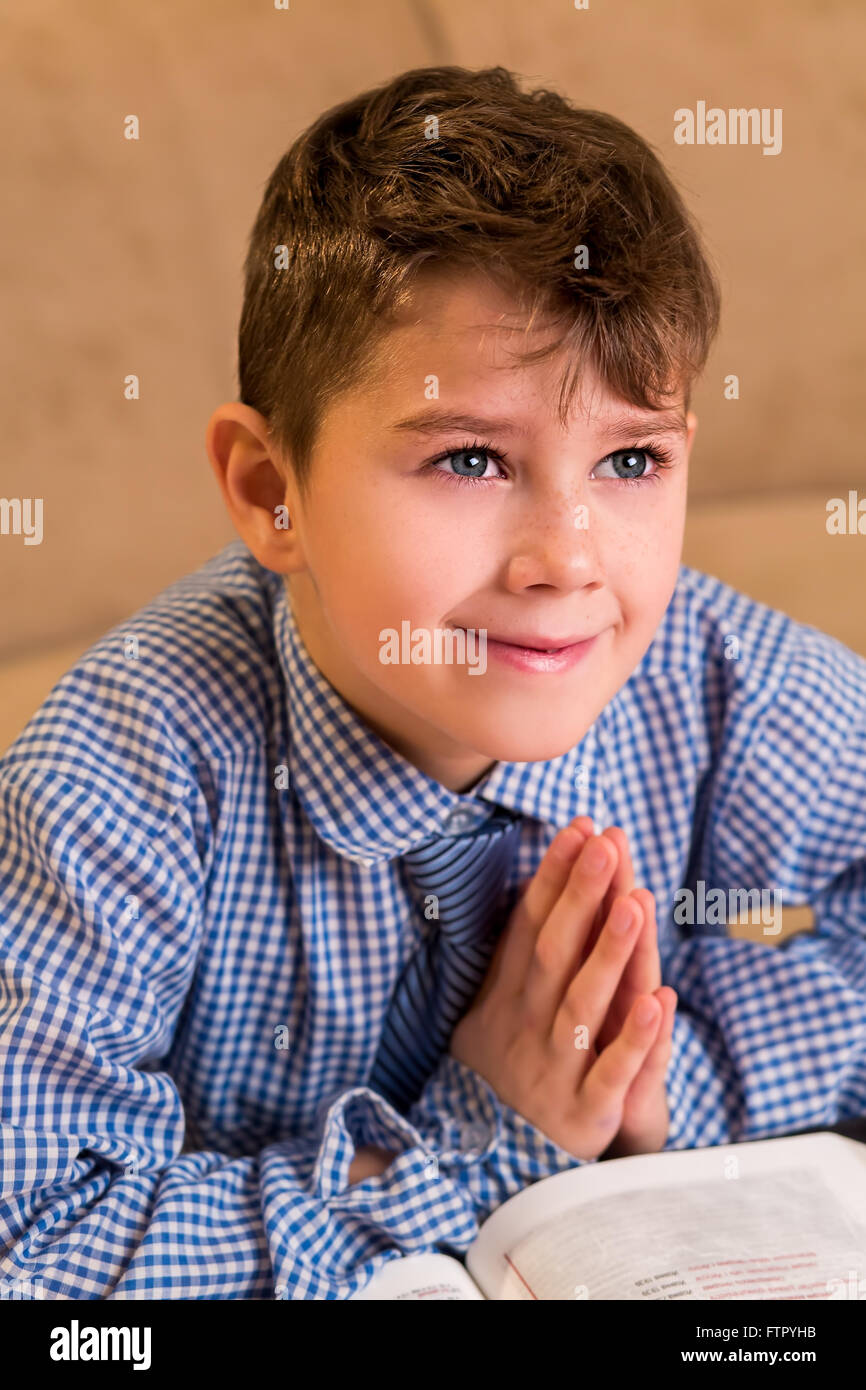 Young boy praying and smiling Stock Photo - Alamy