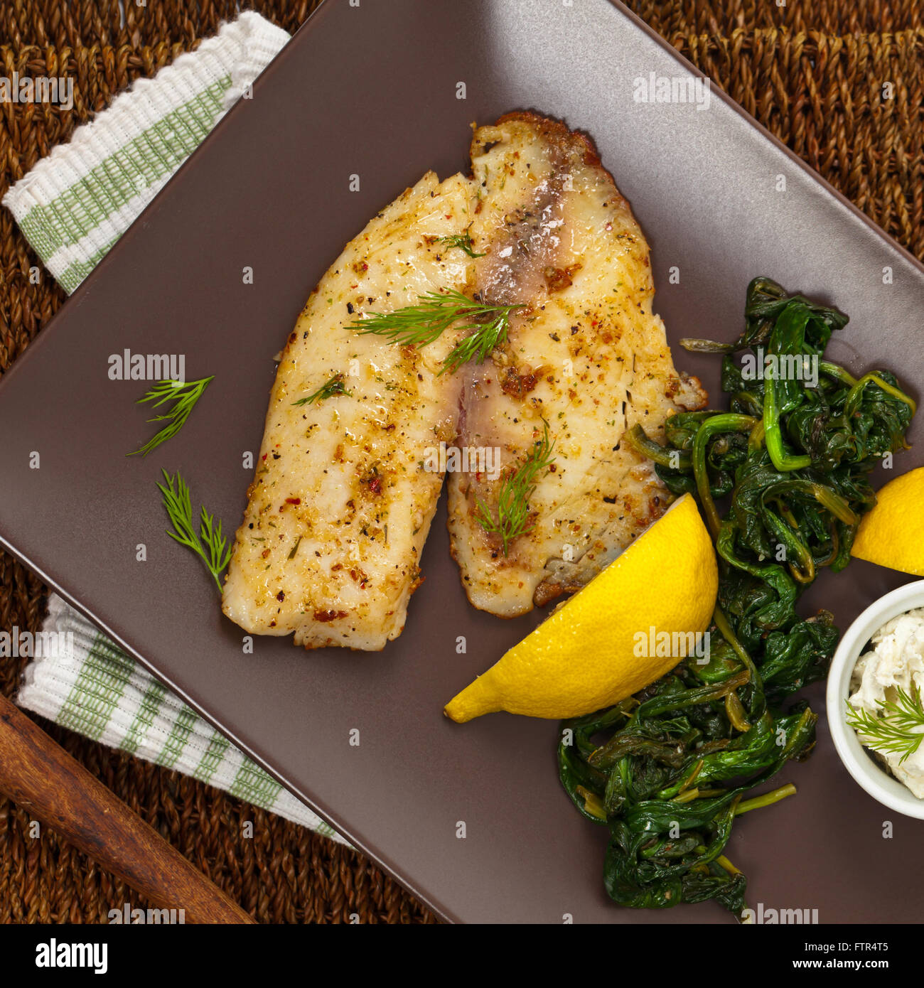 Baked Fish Fillet with Sauteed Spinach Stock Photo - Alamy