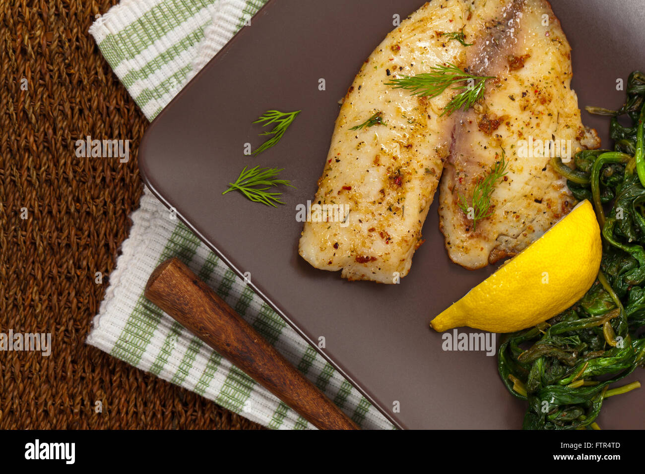 Baked Fish Fillet with Sauteed Spinach Stock Photo - Alamy
