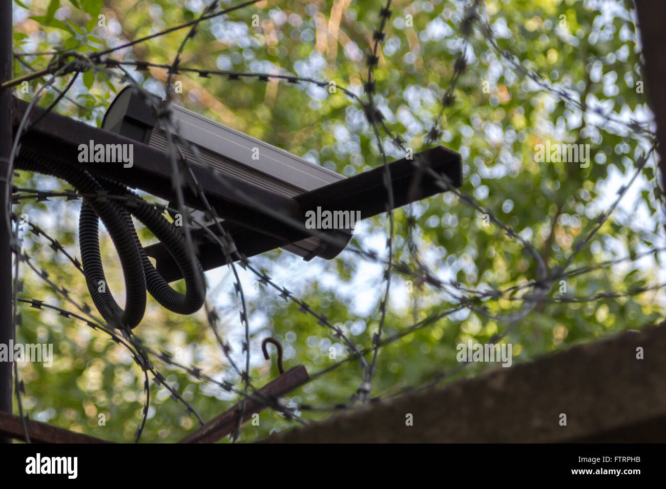 surveillance camera on a concrete fence with barbed wire Stock Photo ...