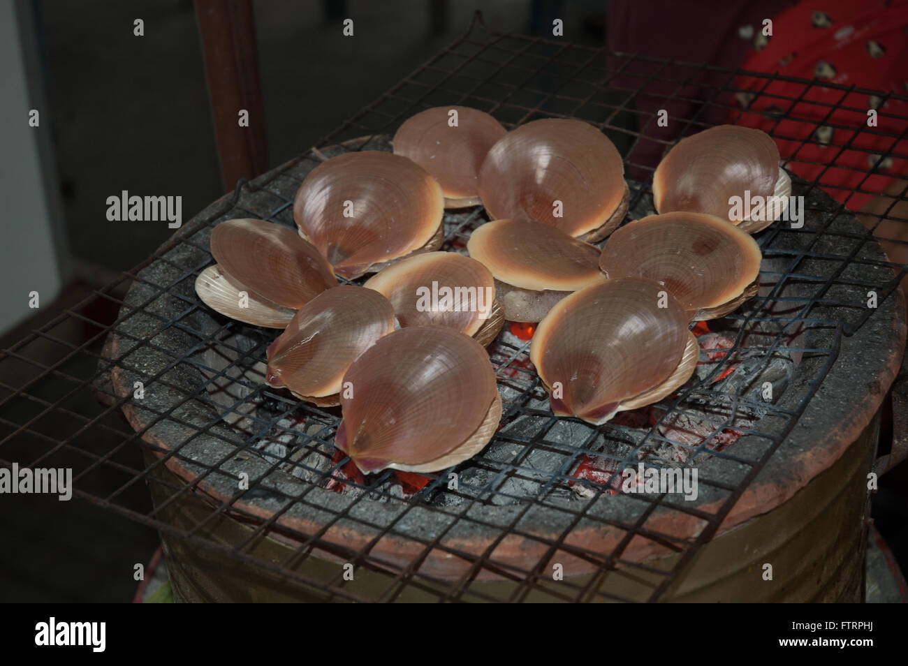 Shellfish cooking over brazier Stock Photo - Alamy