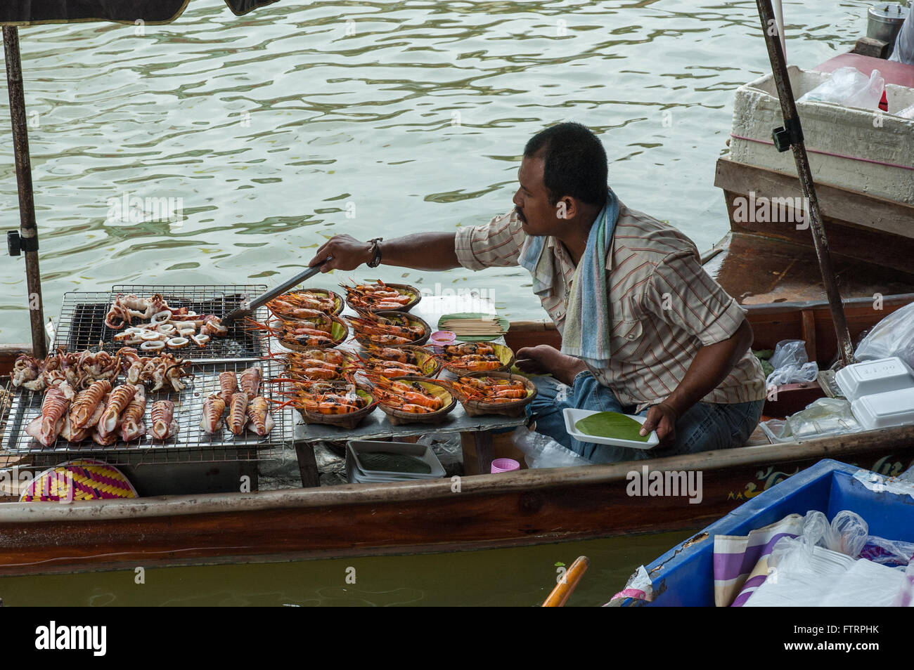 Man cooking seafood in a boat Stock Photo - Alamy
