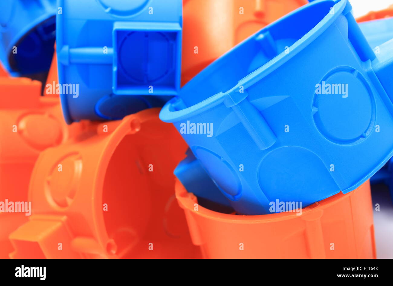 Heap of blue and orange plastic electrical boxes, components for ...