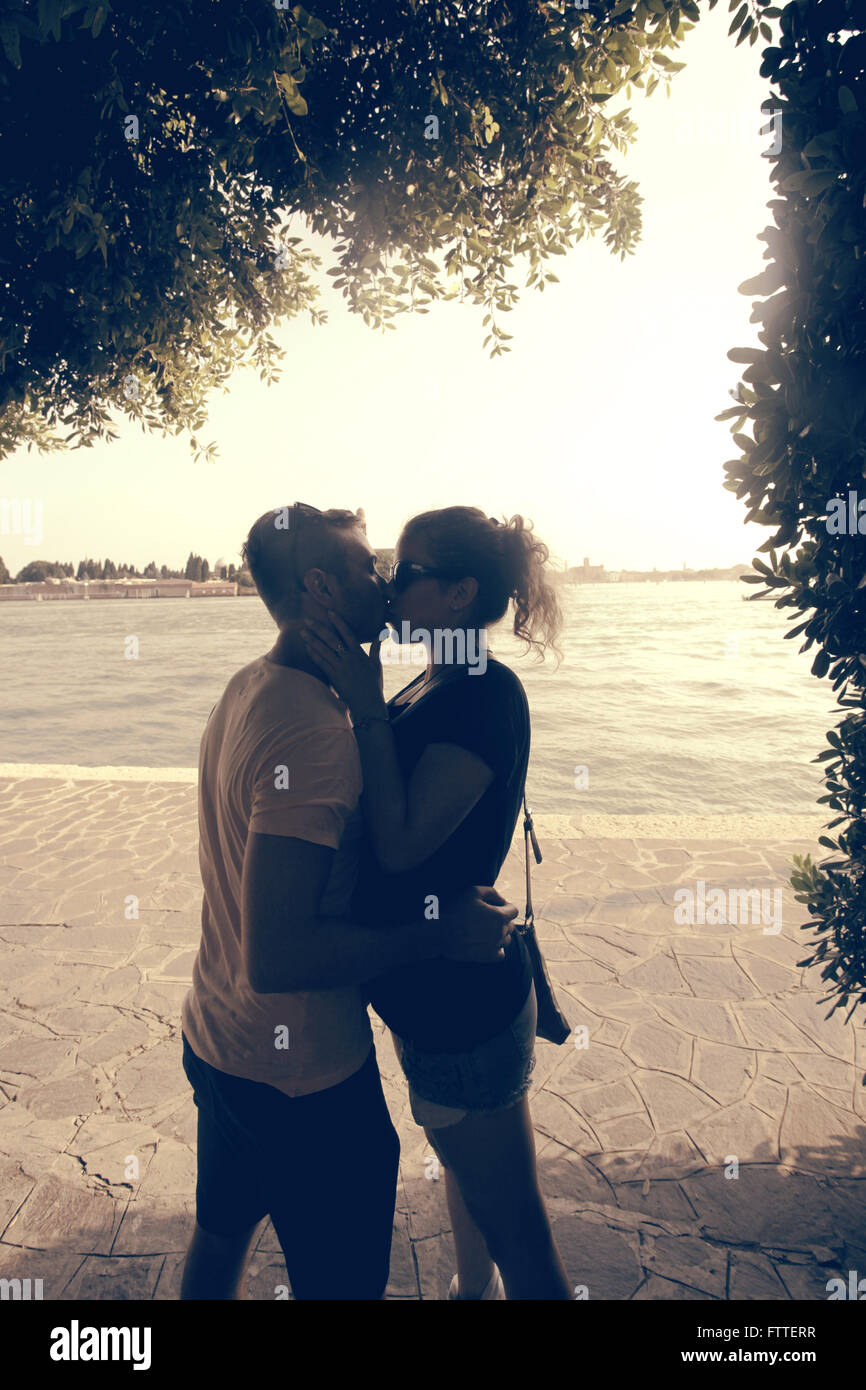 Young couple kissing in the shade Stock Photo - Alamy