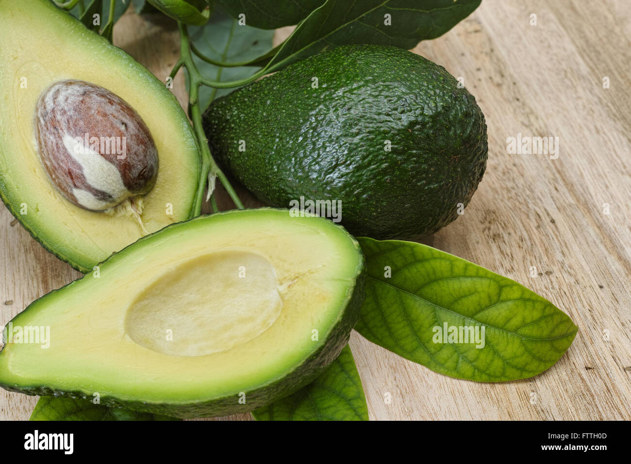 Fresh avocado with avocado leaves on teak wood table top Stock Photo ...