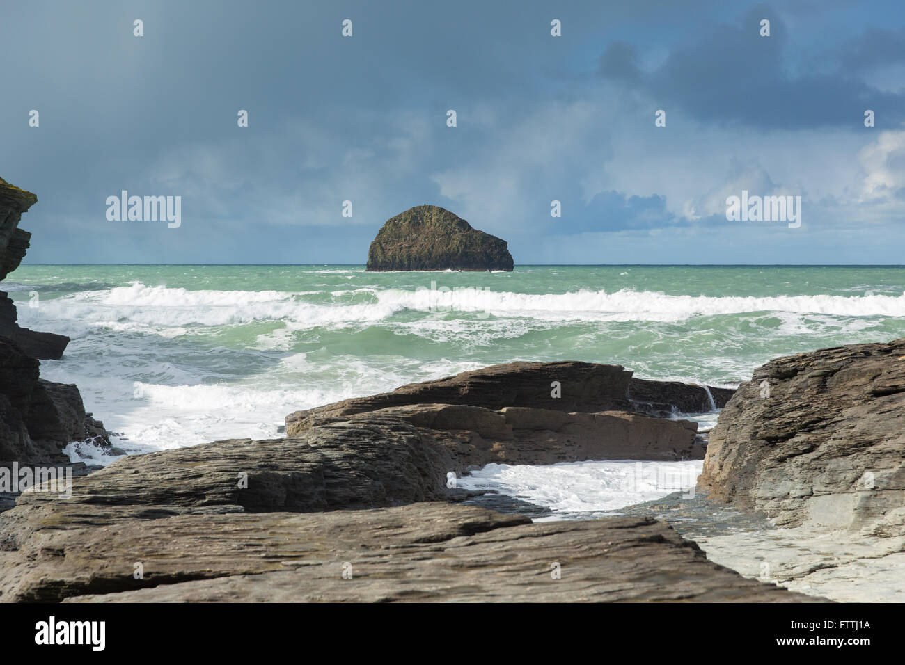 Gull Rock with white waves breaking viewed from the beach Trebarwith ...