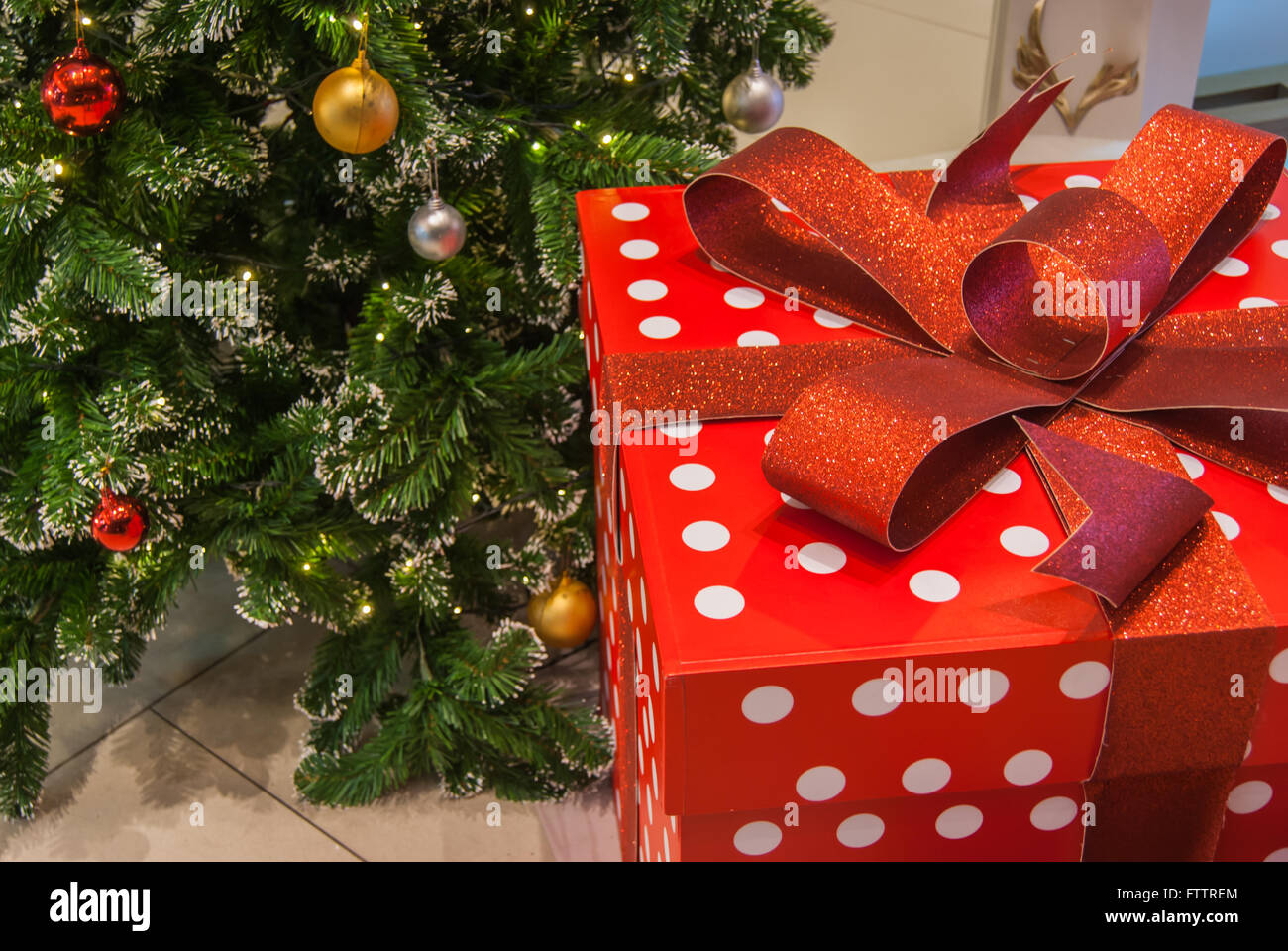 Red Christmas gift box with red ribbon and ornaments of chrisrmas tree ...