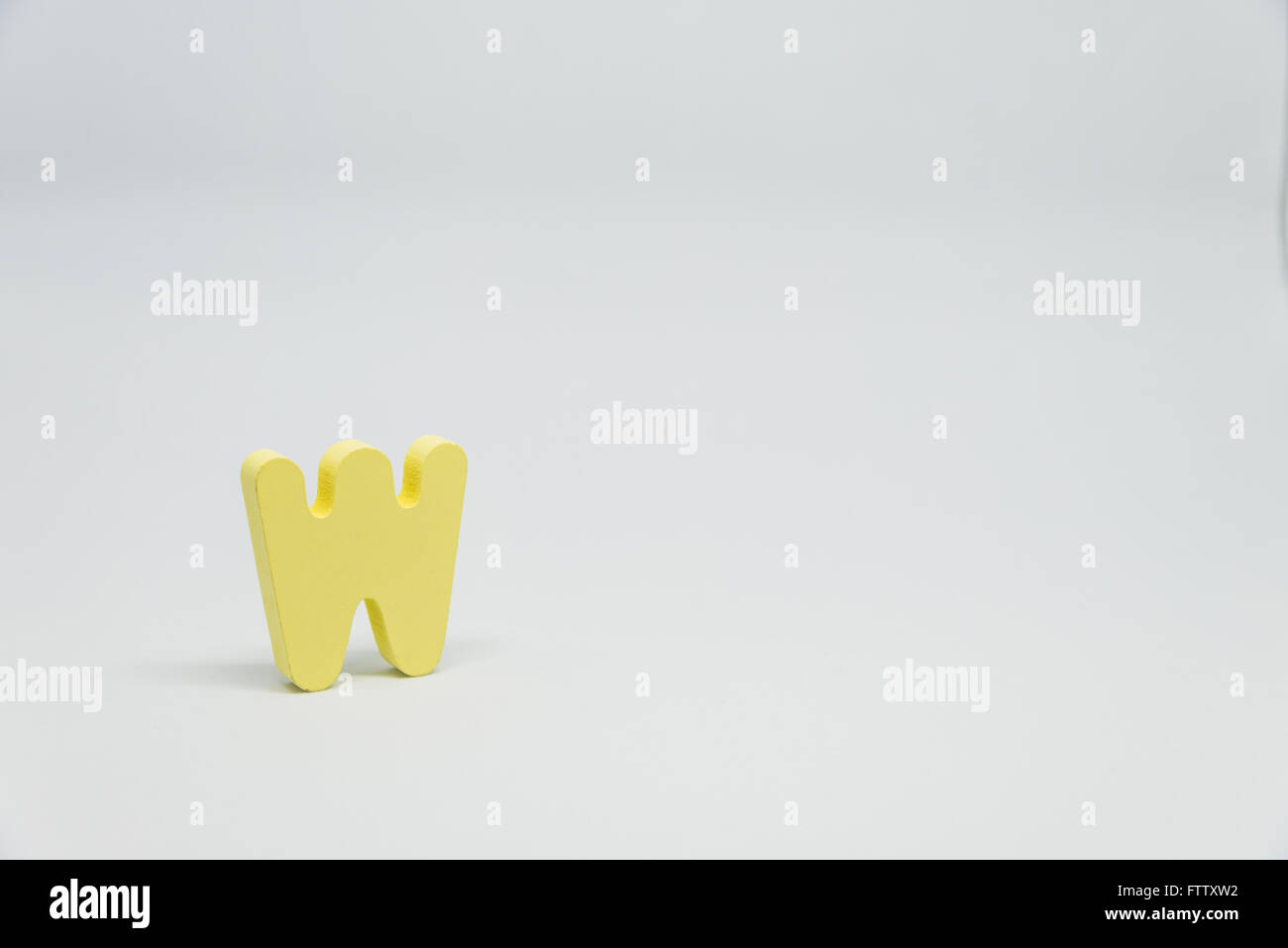 Yellow Wooden alphabet W with white background Stock Photo - Alamy