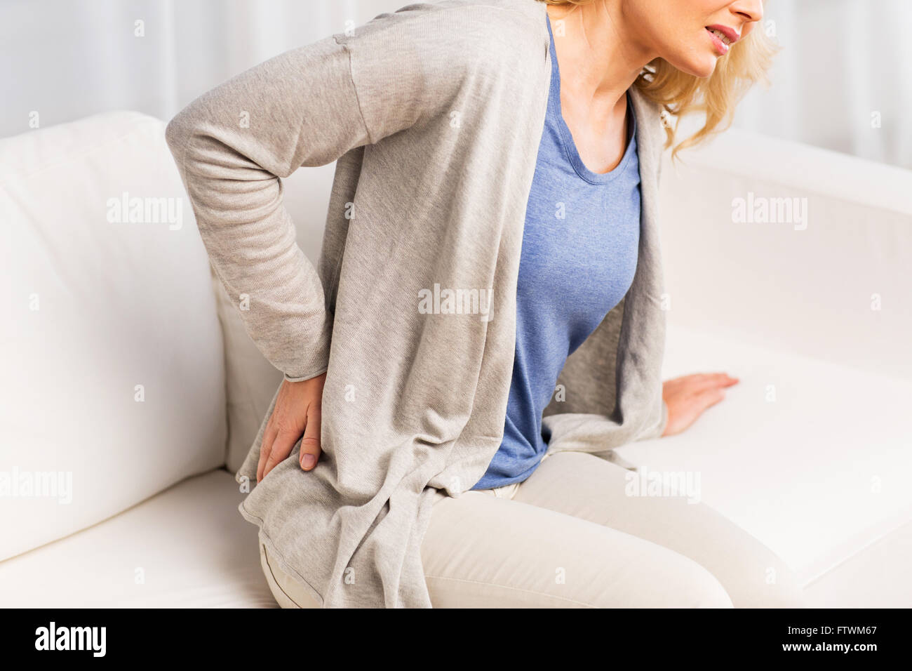 Backache woman sofa hi-res stock photography and images - Alamy