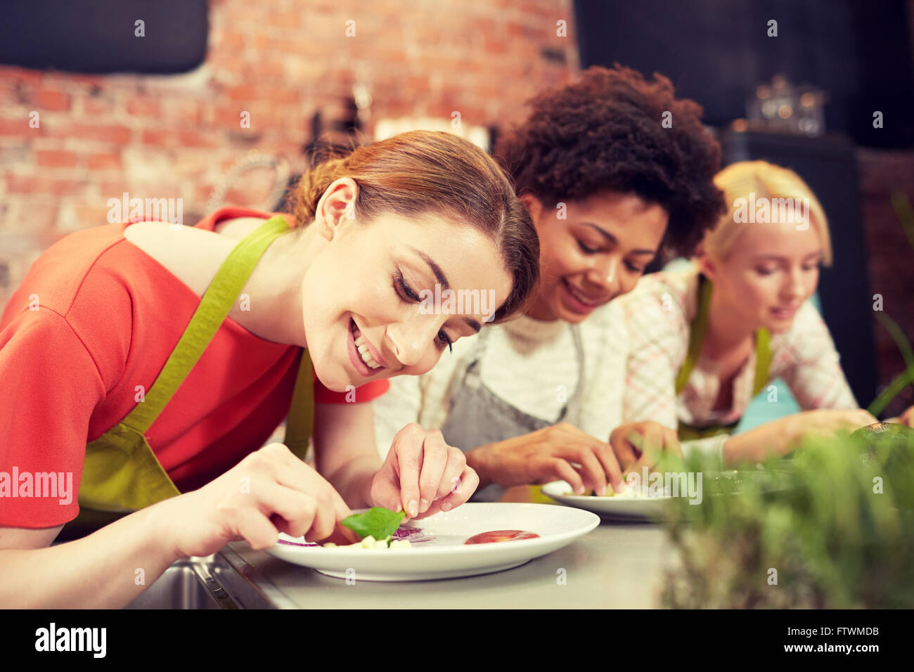 happy women cooking and decorating dishes Stock Photo - Alamy