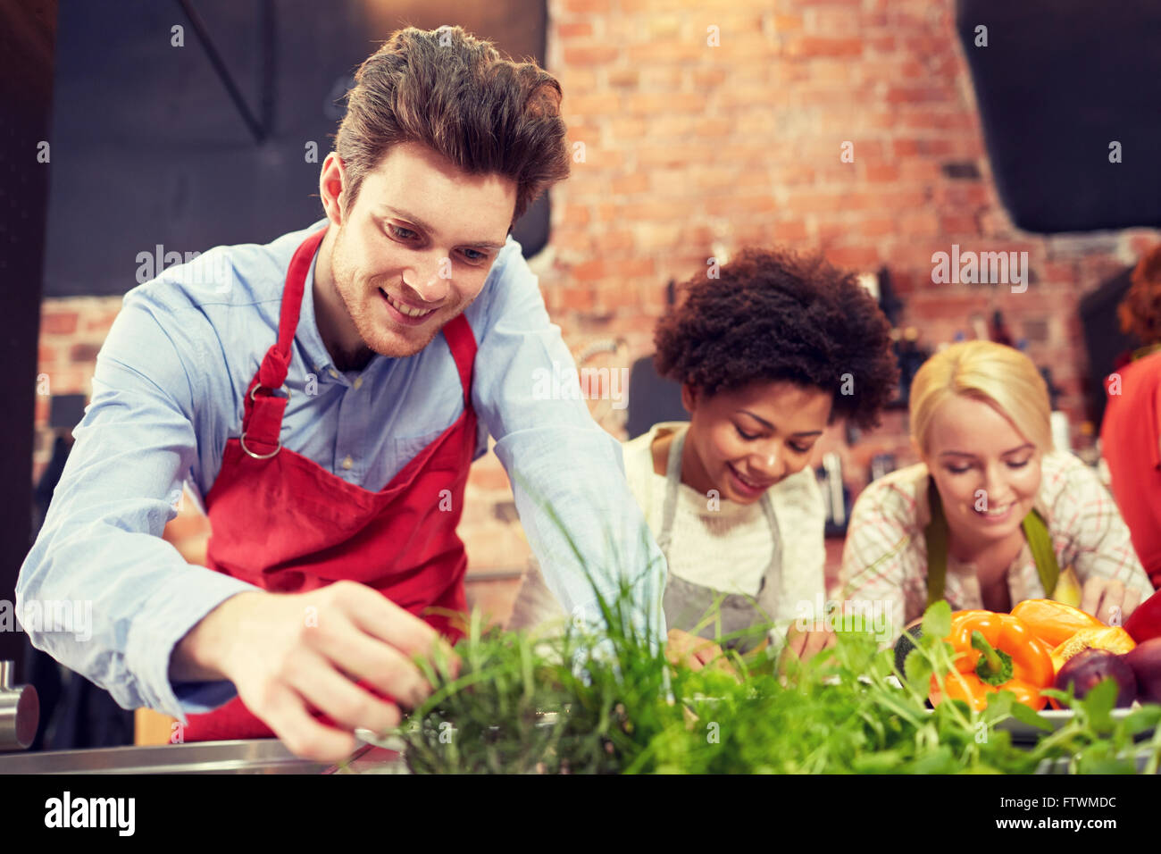 happy friends cooking and decorating dishes Stock Photo - Alamy