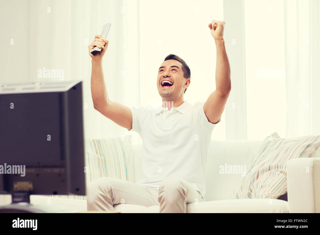 smiling man watching sports at home Stock Photo - Alamy