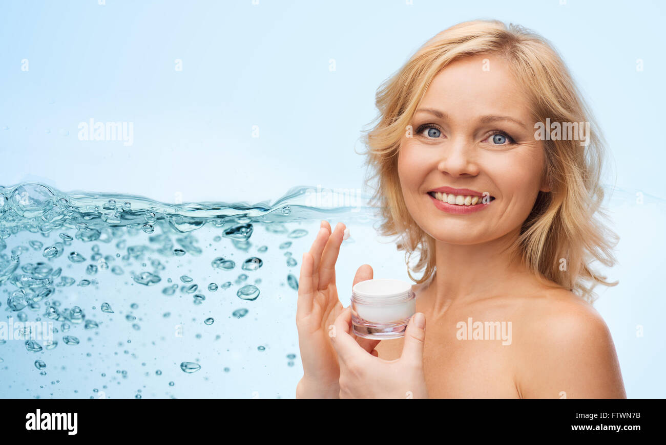happy woman applying cream to her face Stock Photo - Alamy