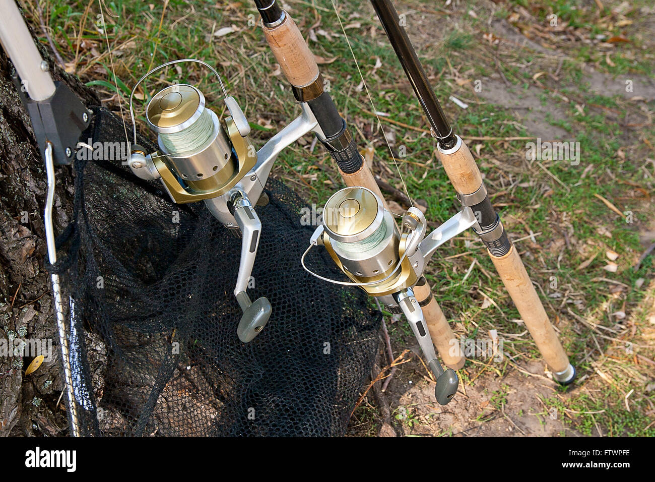 Fishing rods with reels and landing net on the natural background ...