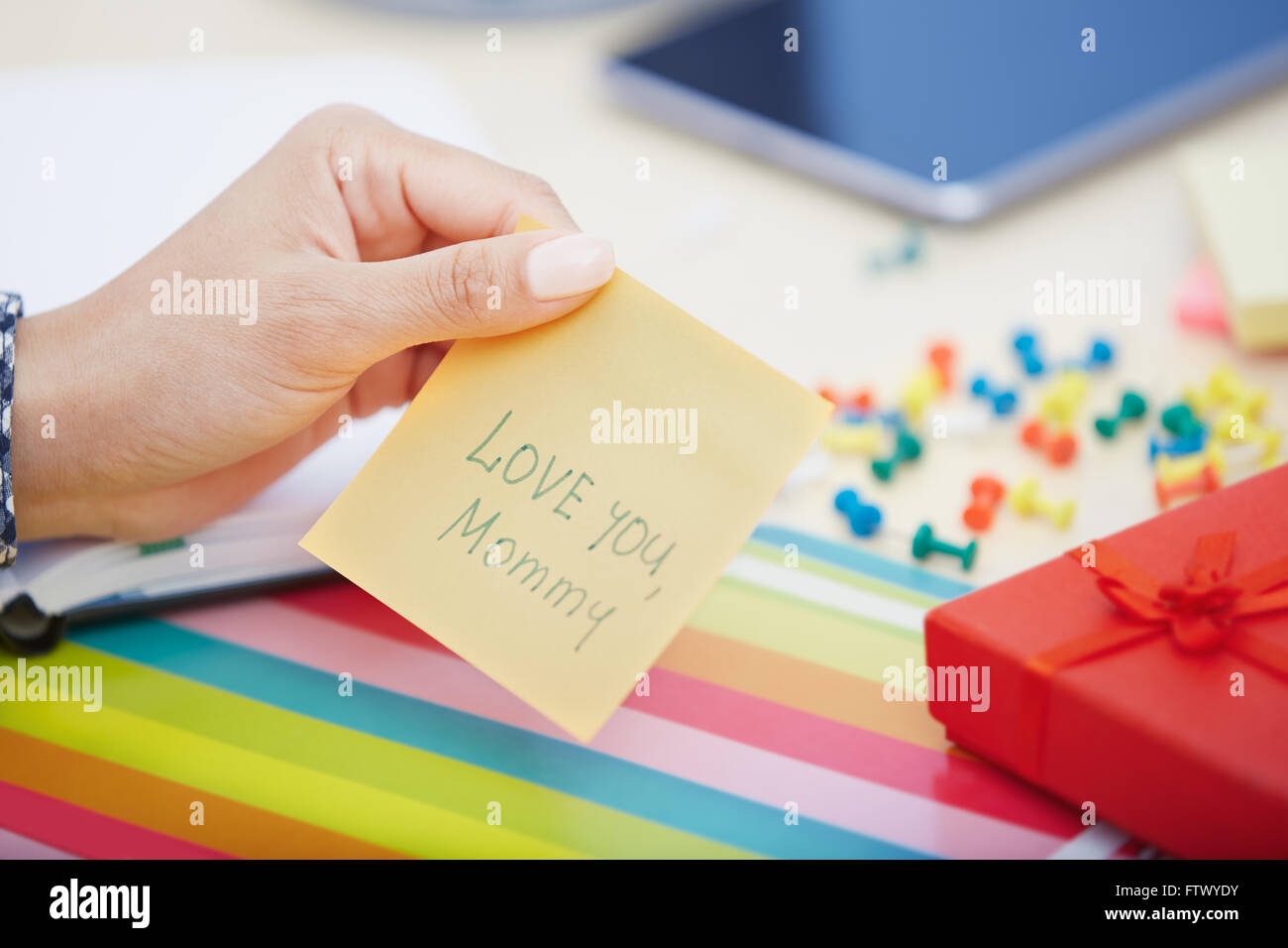 Human hand holding adhesive note with Love you mommy text Stock Photo ...