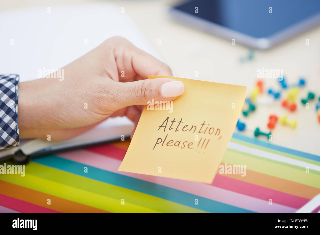 Human hand holding adhesive note with Attention please text Stock Photo ...