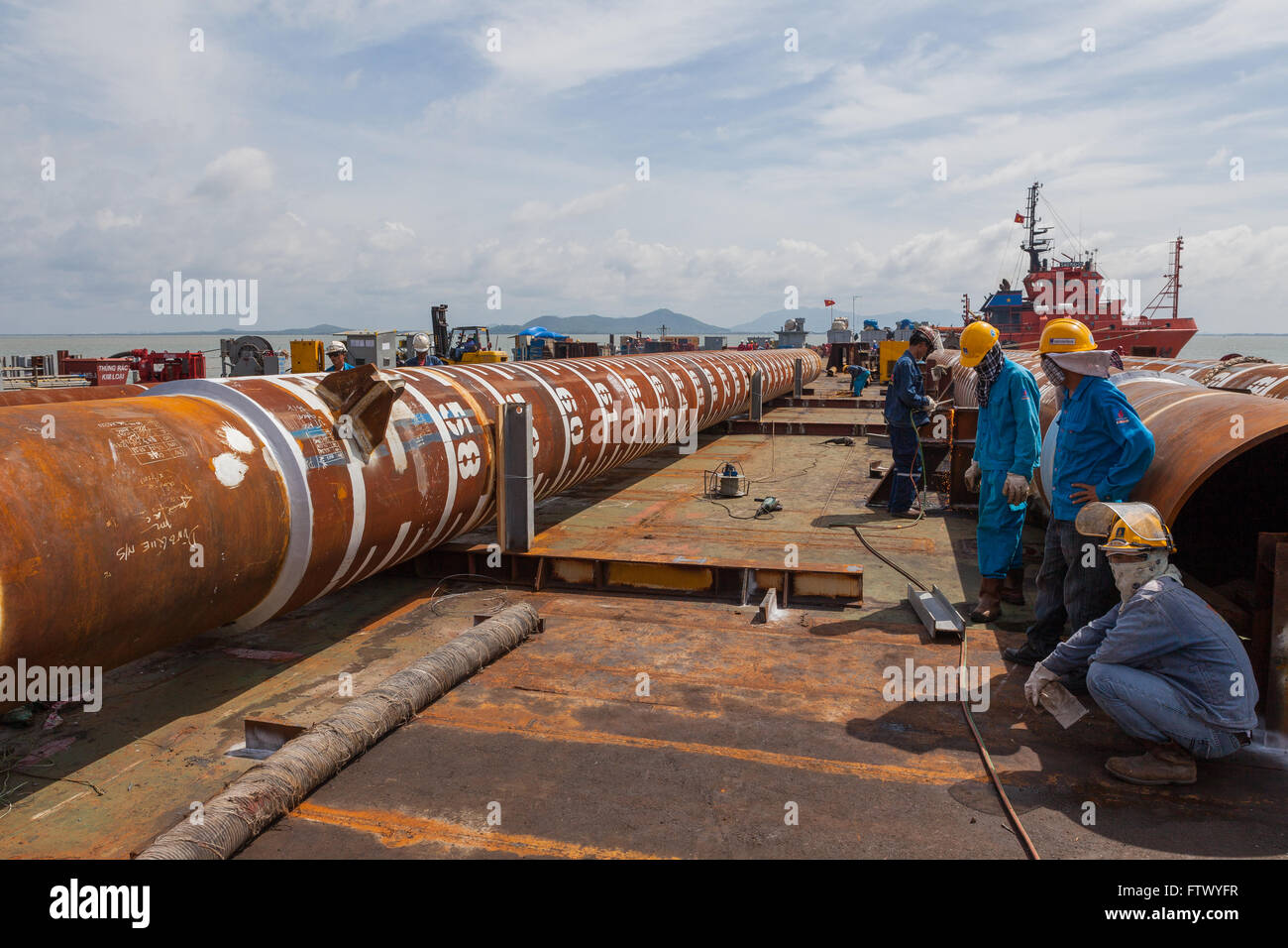 Men working in front of a rig pile Stock Photo - Alamy