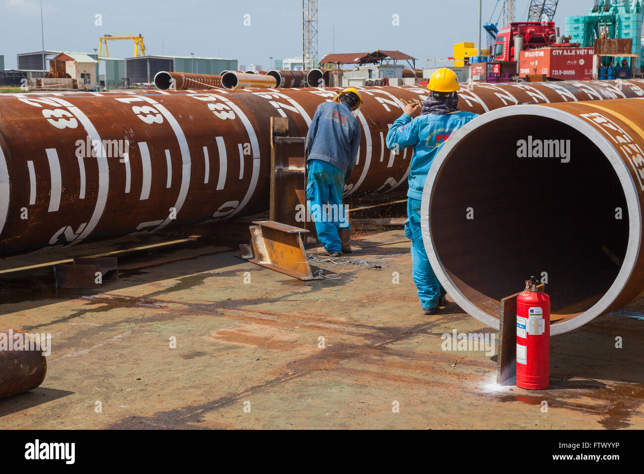 Men working in front of a rig pile Stock Photo - Alamy