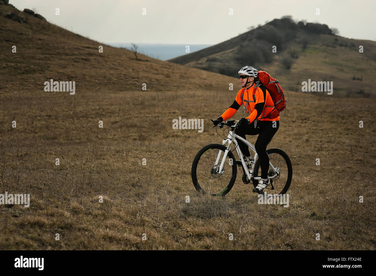 Man cyclist with backpack riding the bicycle Stock Photo - Alamy