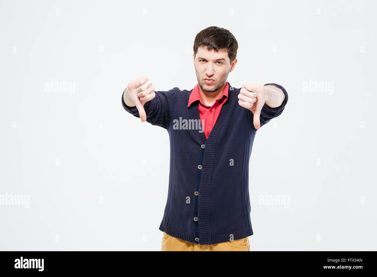 Young casual man showing thumbs down isolated on a white background ...