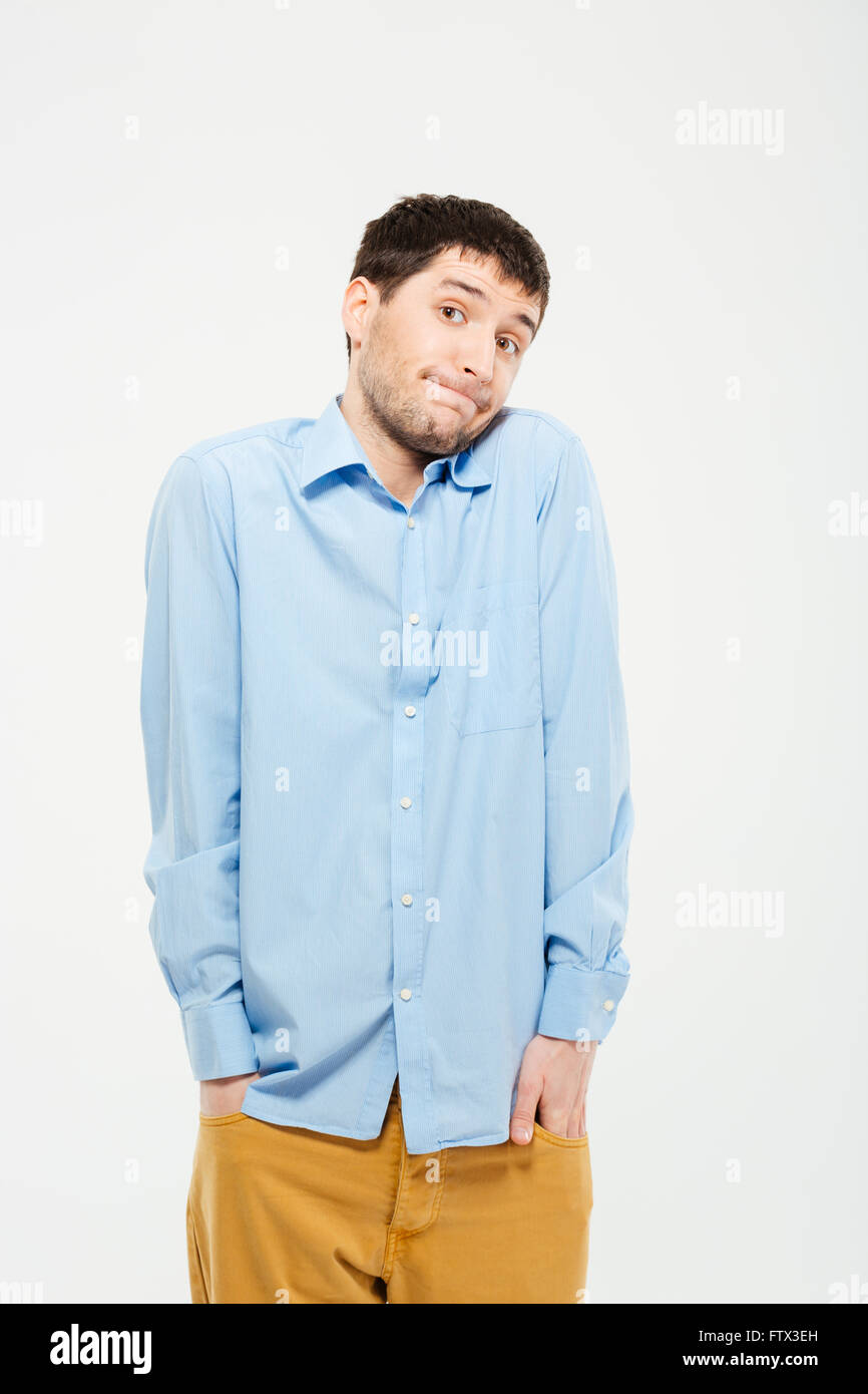 Portrait of a young man shrugging shoulders isolated on a white ...
