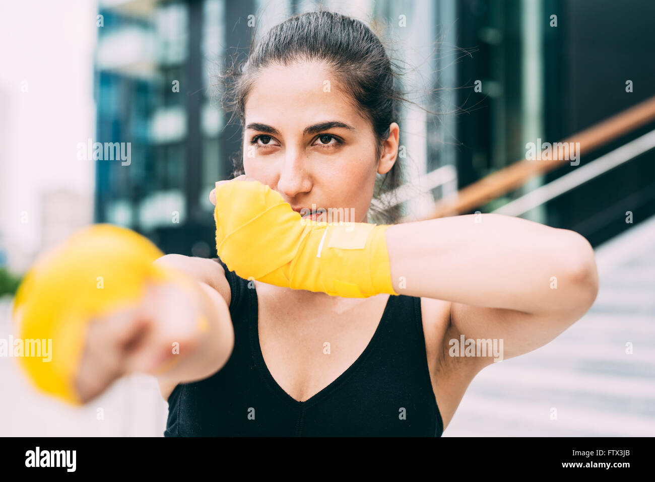 Half length of a young handsome caucasian brown hair boxer woman boxing ...