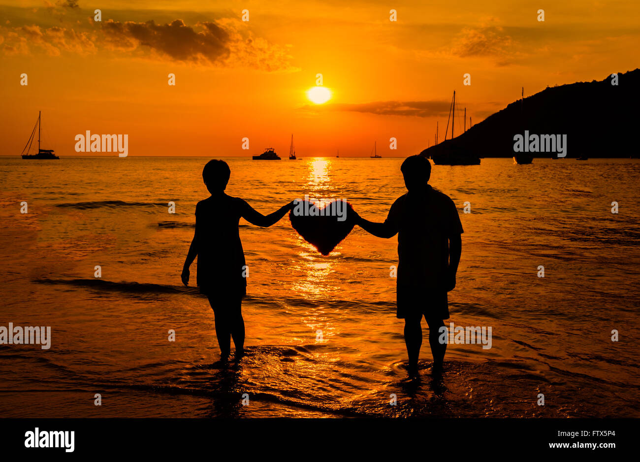 Silhouette of a couple on the beach at sunset Stock Photo - Alamy