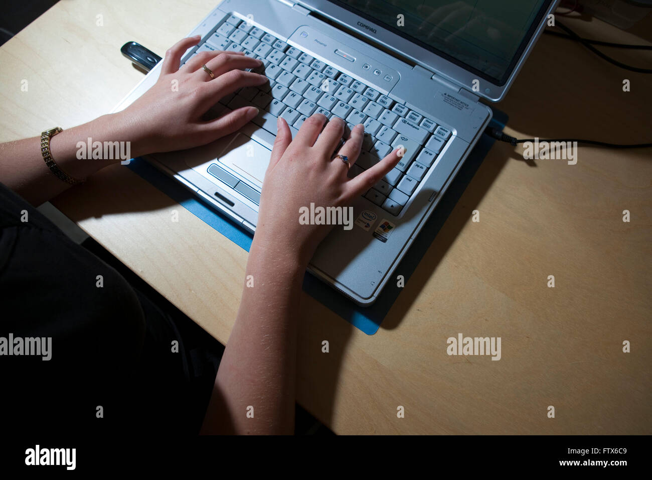 A girl or ladies / female pair of hands typing on the keyboard of a ...