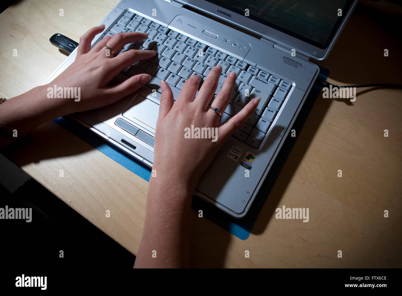 A girl or ladies / female pair of hands typing on the keyboard of a ...