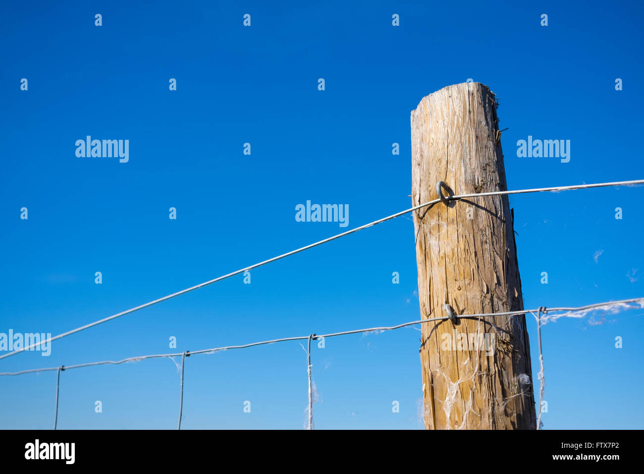 Boundary fence with post against clear blue sky Stock Photo - Alamy