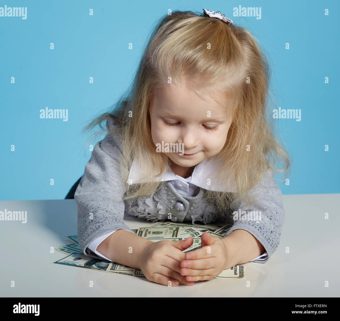 little child with dollars on table Stock Photo - Alamy