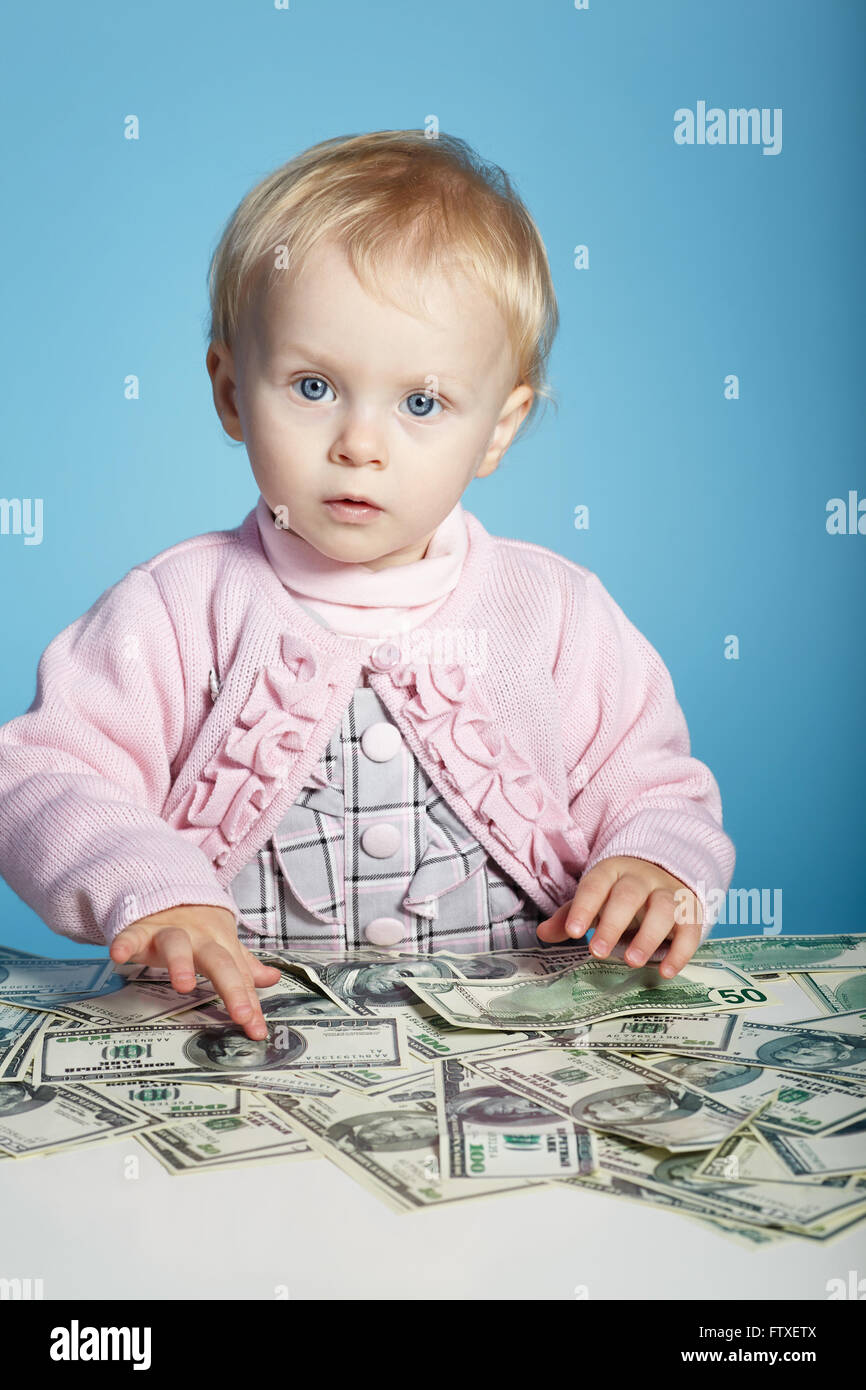 little child with dollars on table Stock Photo - Alamy