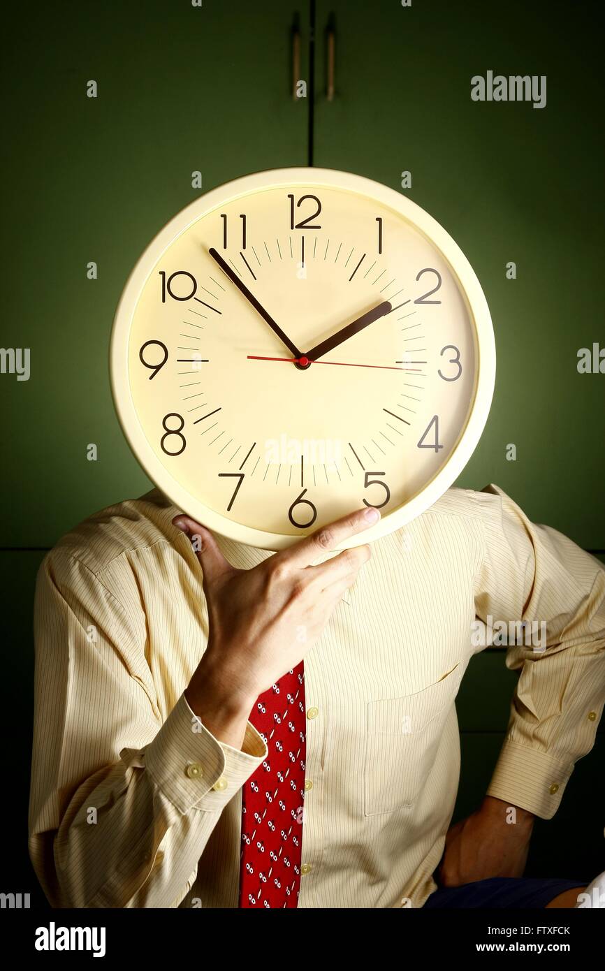 Man holding a clock to his face Stock Photo - Alamy