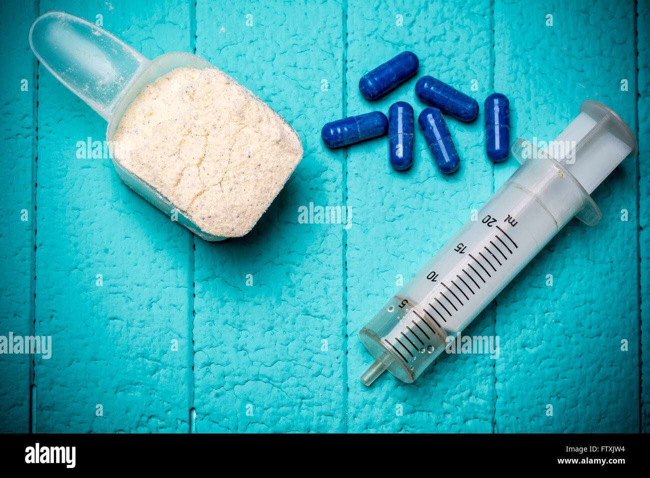 Container of milk whey protein, empty injection and pills. Close-up ...