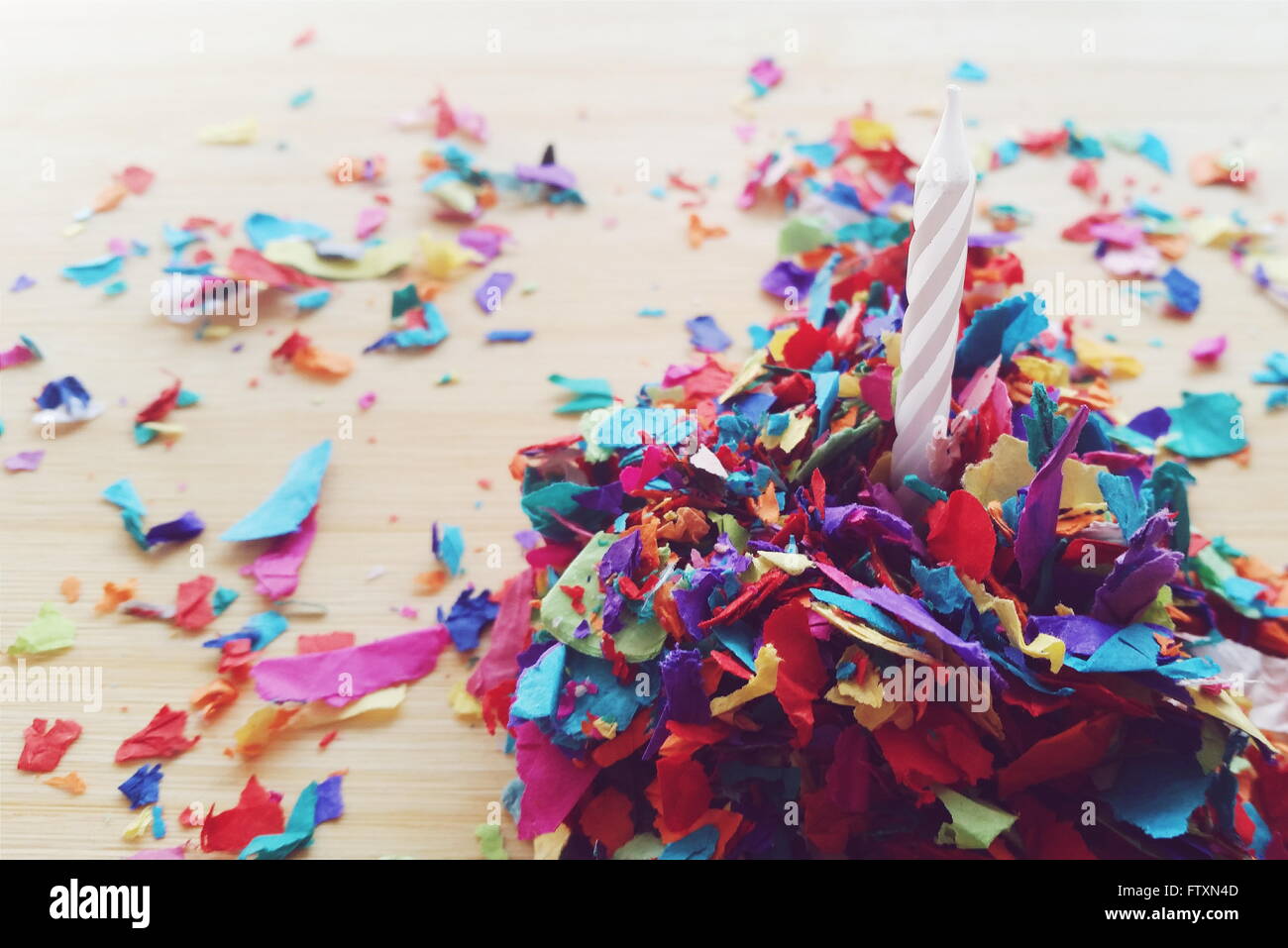 Multi-colored confetti and a candle Stock Photo - Alamy