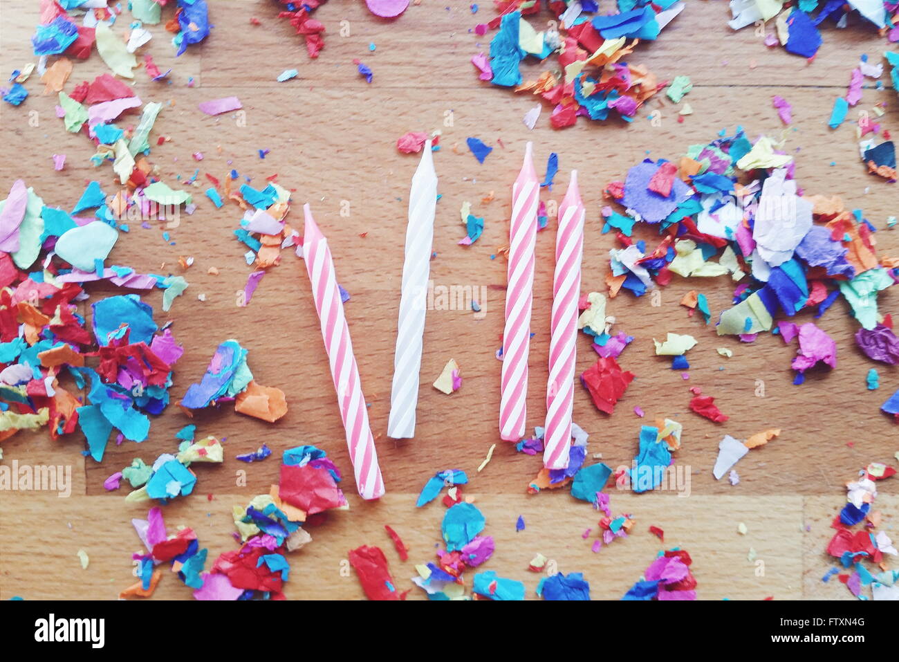 Four candles and confetti Stock Photo - Alamy