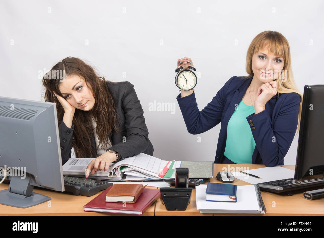 Two office workers wait for the end of the working day Stock Photo - Alamy