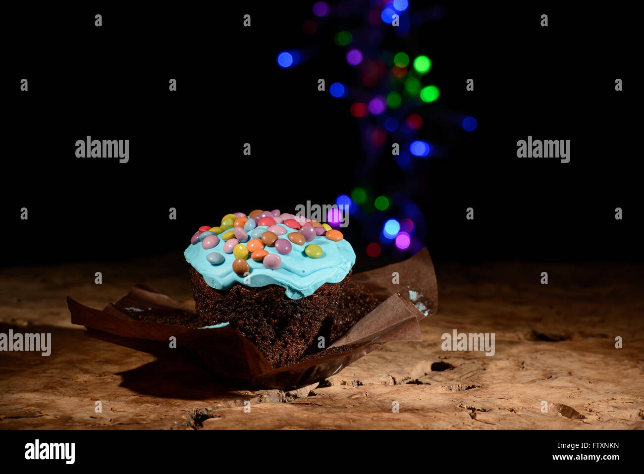 Chocolate muffin decorated with icing and multi coloured sweets Stock ...