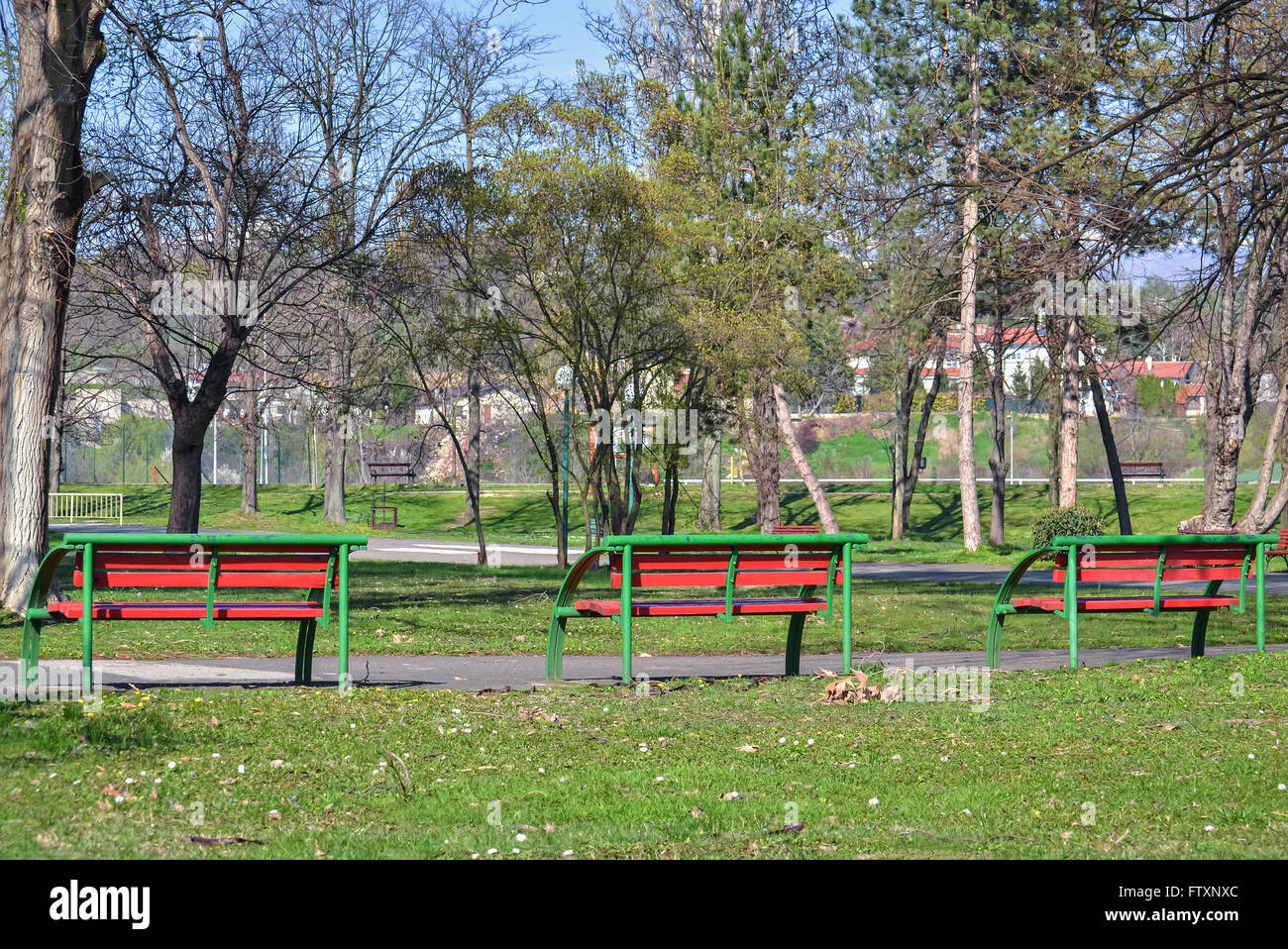 Three red benches under the trees in the city park Stock Photo - Alamy