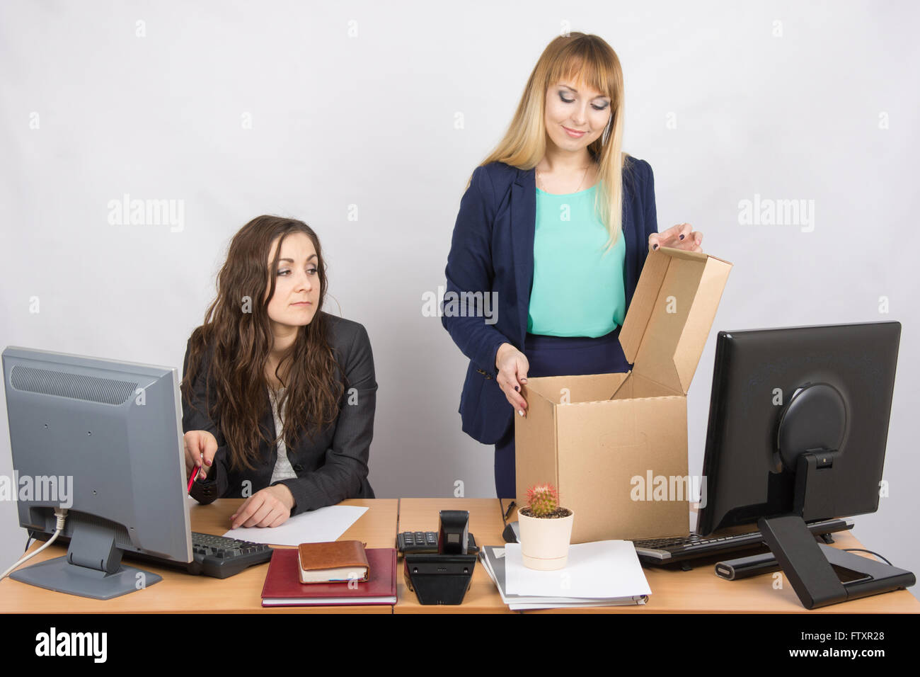 An employee in the office watching a new colleague who arranges things ...
