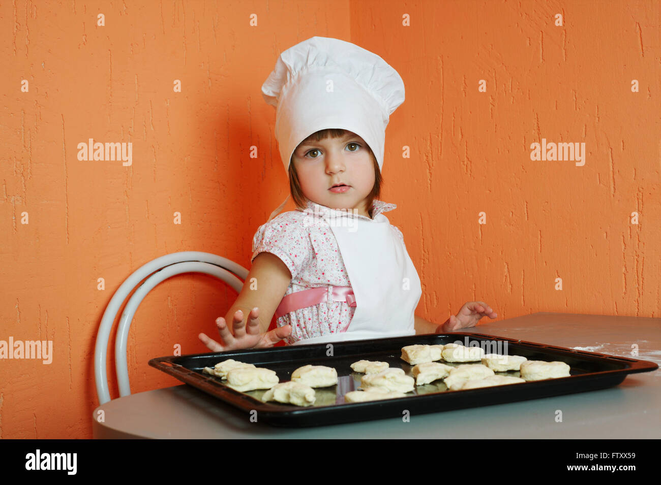 little cute chef cooking biscuits Stock Photo - Alamy