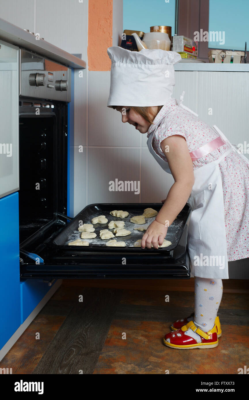 little cute chef cooking in the oven Stock Photo - Alamy