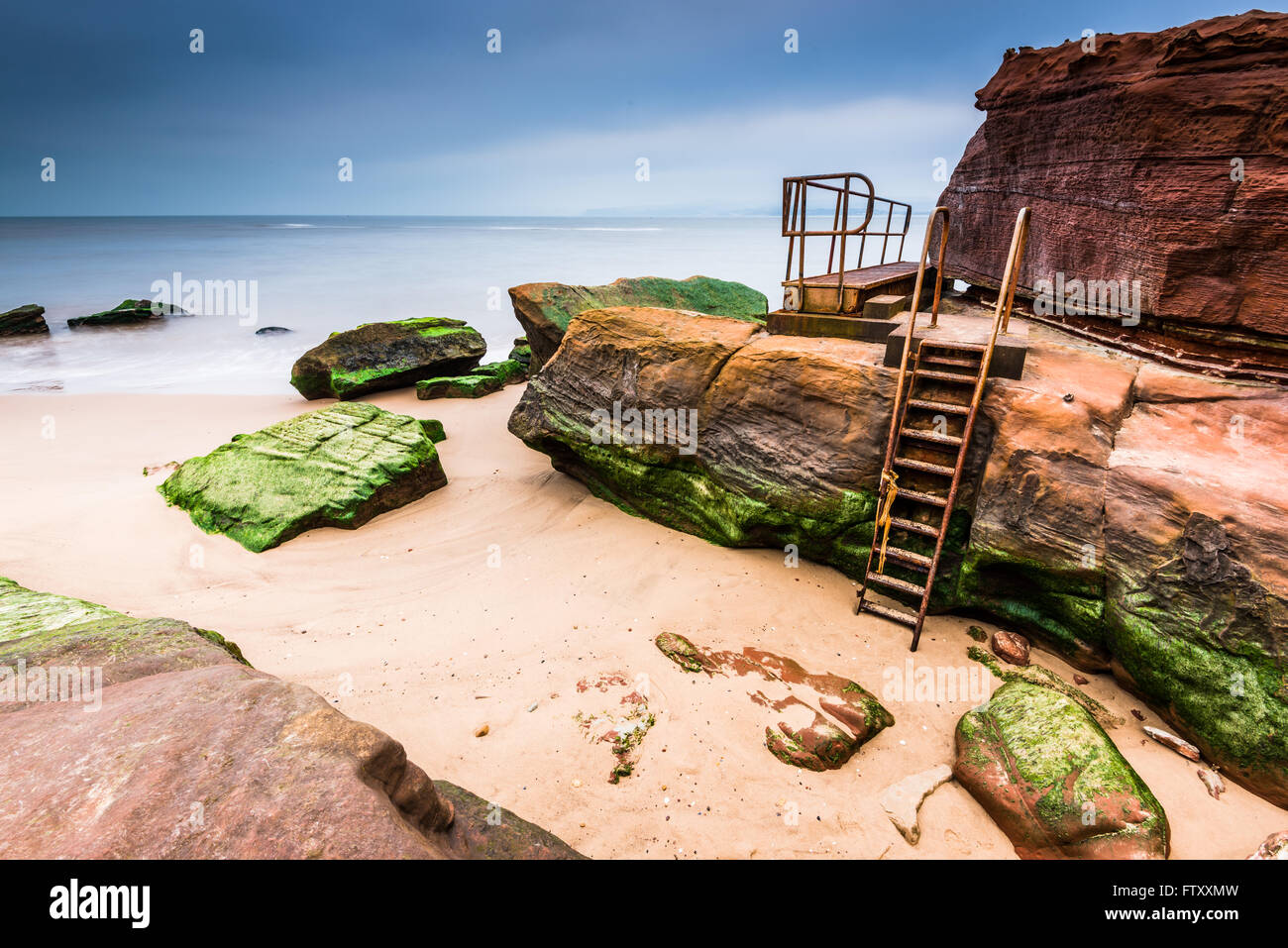 Wild beach and red rock cliffs in famous heritage site Jurassic Coast ...