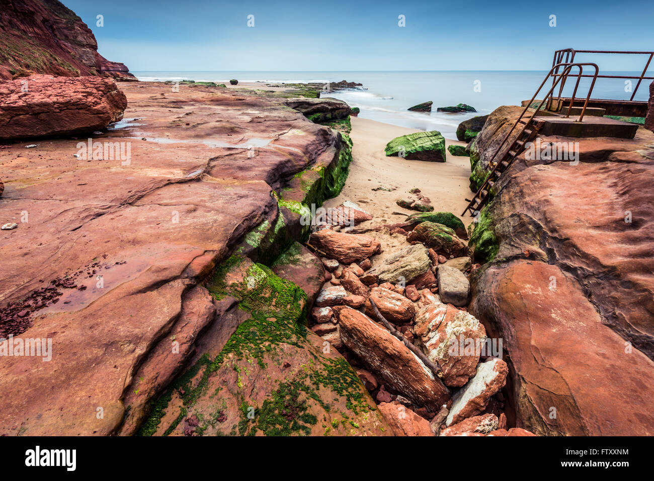 Wild beach and red rock cliffs in famous heritage site Jurassic Coast ...