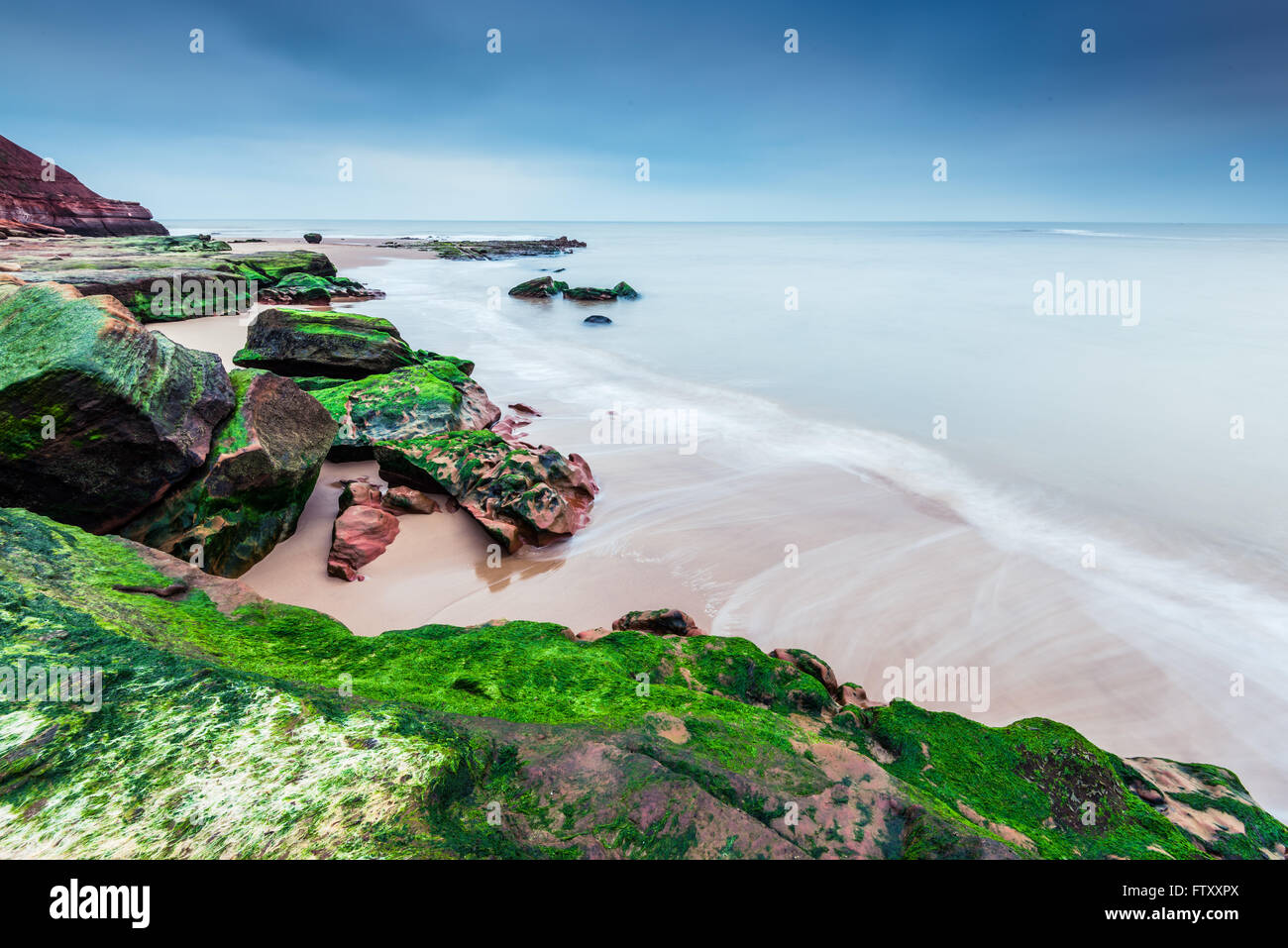 Wild beach and red rock cliffs in famous heritage site Jurassic Coast ...