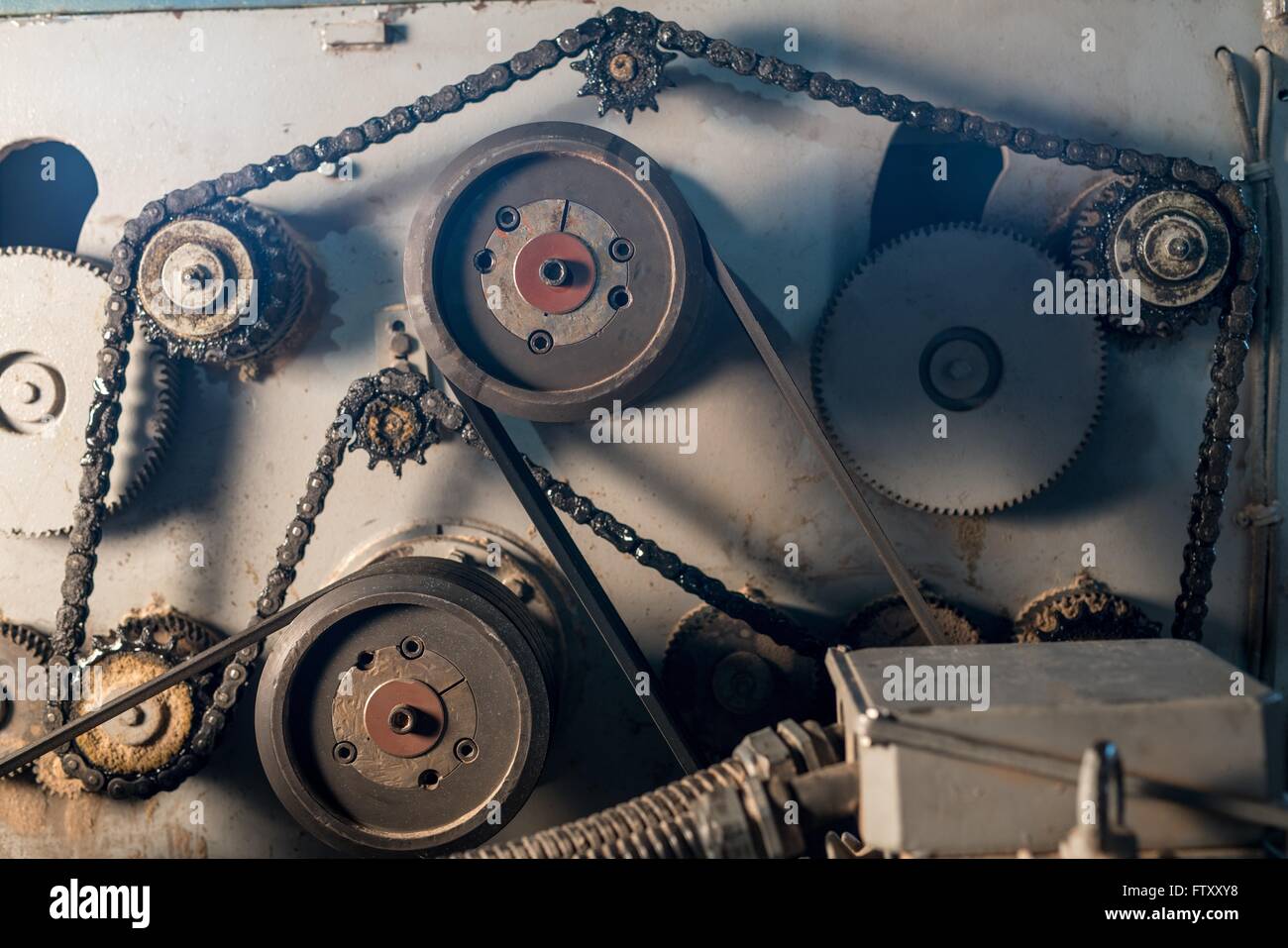 At sawmill. Gears and chain on machine Stock Photo - Alamy