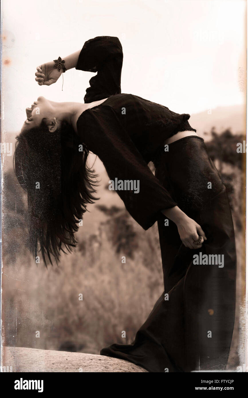 Old photo feel. Witch like woman bending over backwards Stock Photo - Alamy