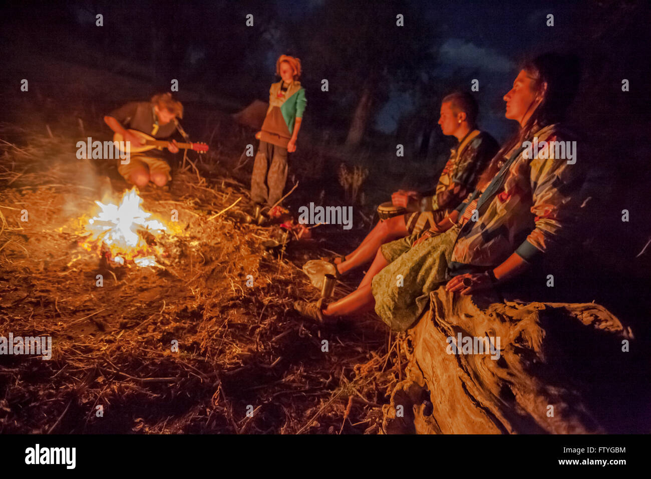 Kazakhstan, Kazakistan,men and women around the fire are watching man ...